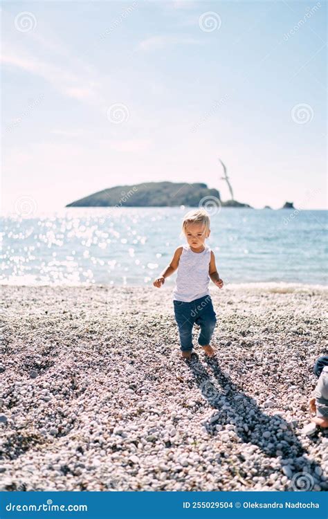 Petite Fille Marchant Pieds Nus Sur Une Plage De Galets Photo Stock