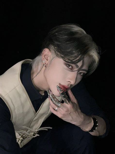 A Man With White Hair And Piercings Holding Something In His Mouth