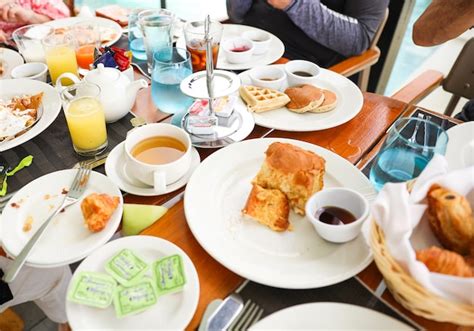 Una Mesa Llena De Comida Que Incluye Panqueques Y Tortitas Foto Premium