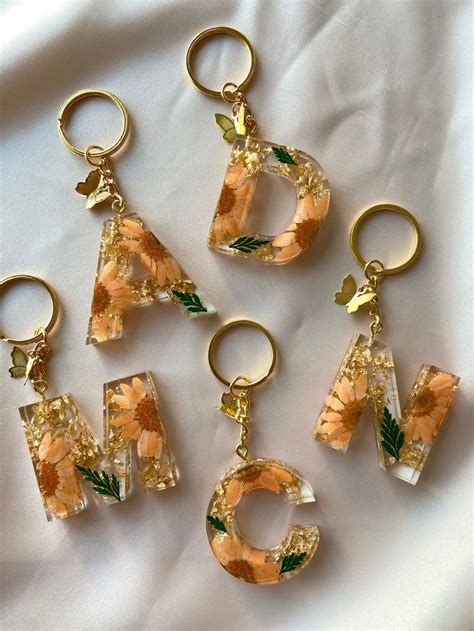Four Pieces Of Glass With Flowers And Leaves Hanging From Gold Colored