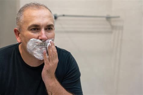 Premium Photo Middle Aged Handsome Man Shaving His Beard In Bathroom