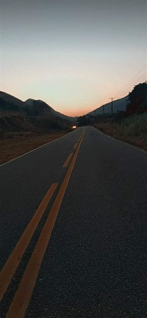 The Sun Is Setting On An Empty Road