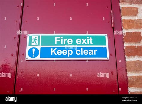 Fire Exit Keep Clear Sign Against A Red Door Stock Photo Alamy