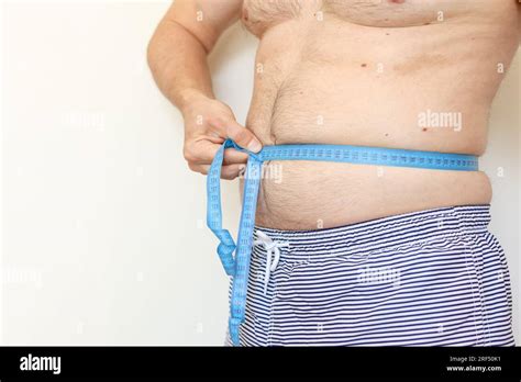 A Man Measures His Fat Belly With Measuring Tape Concept Of Weight