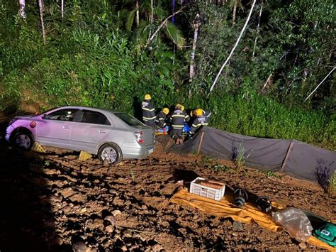 Mulher fica presa às ferragens após carro cair em barranco às margens
