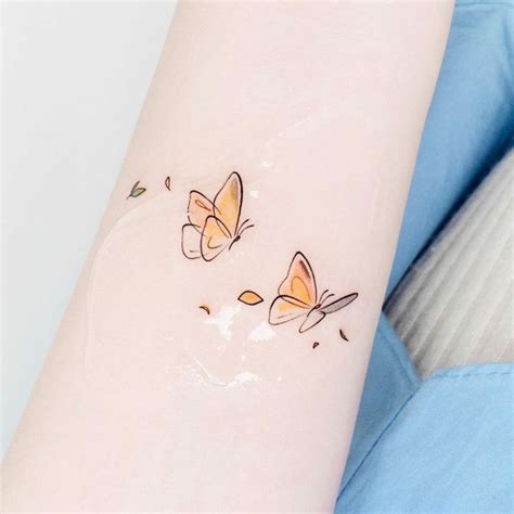 Two Butterflies Are On The Arm Of A Woman