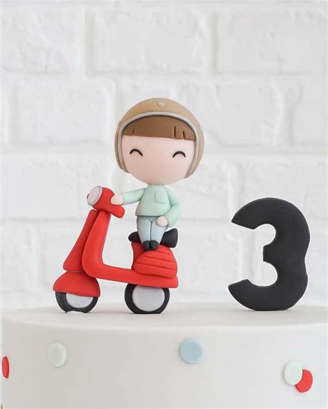 A Cake With A Small Figurine Sitting On Top Of It Next To The Number Three