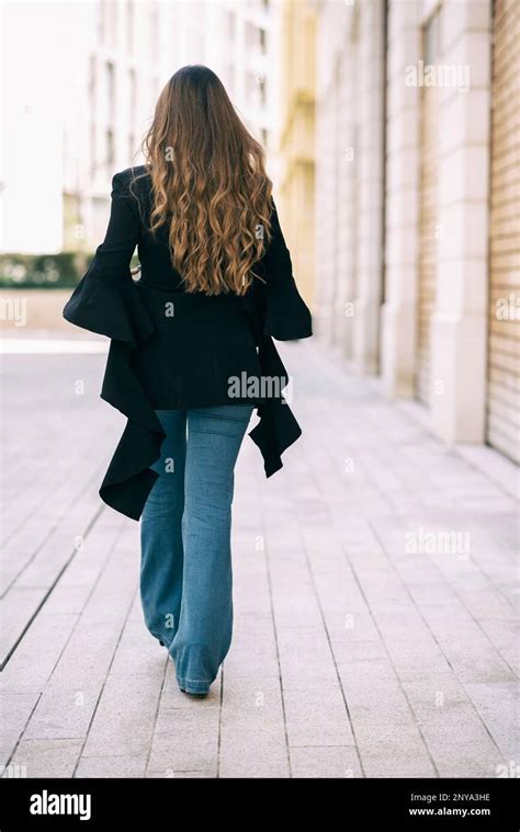 Woman Walking Away On The Street Stock Photo Alamy