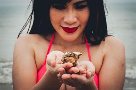 Premium Photo Portrait Of Woman Holding Hermit Crab At Beach