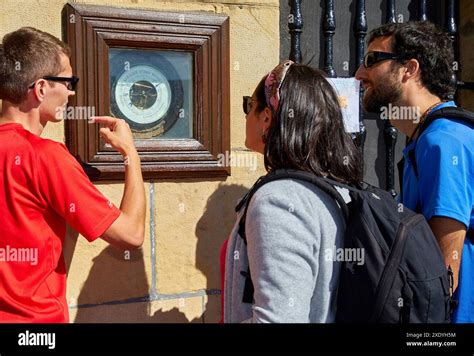 Barometer Guide And Group Of Tourists Visiting The City Plaza