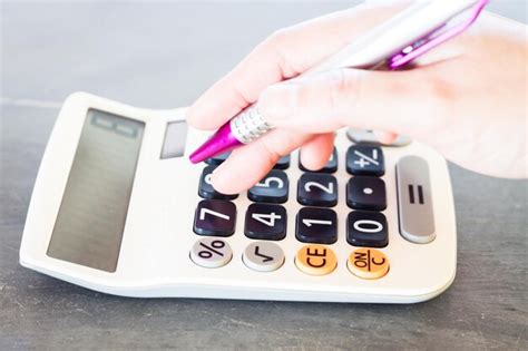 Premium Photo Cropped Hand Using Calculator On Table
