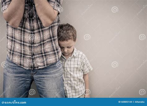 Hijo Triste Que Abraza A Su Pap Cerca De La Pared Foto De Archivo