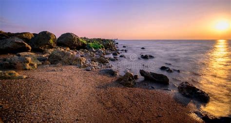 Toma De Una Playa De Arena Y Rocas Brillando Bajo La Impresionante
