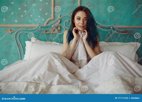 La Mujer Que Estira En Cama Después De Despierta Foto de archivo