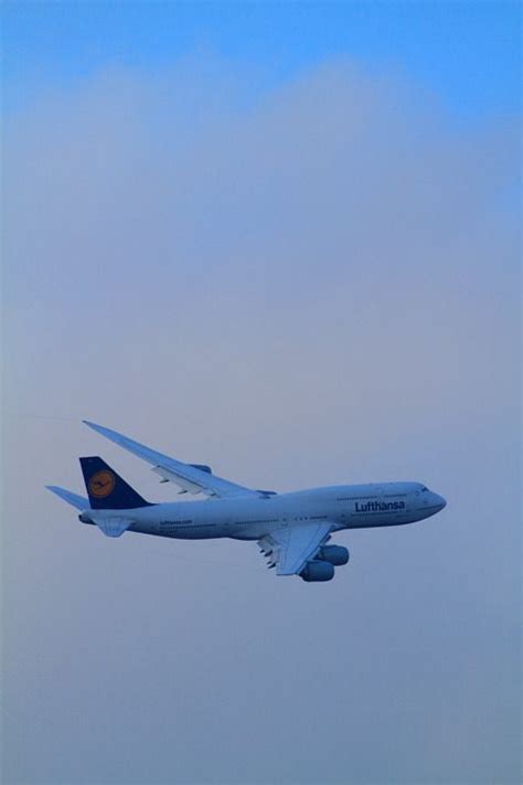 An Airplane Is Flying In The Sky On A Cloudy Day With No One Around It