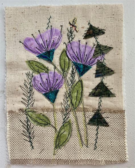 Some Purple Flowers And Green Leaves On A Piece Of Burlied Fabric With