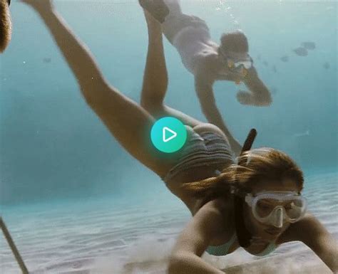 Two People Swimming In The Ocean With Snorkels On Their Feet And One