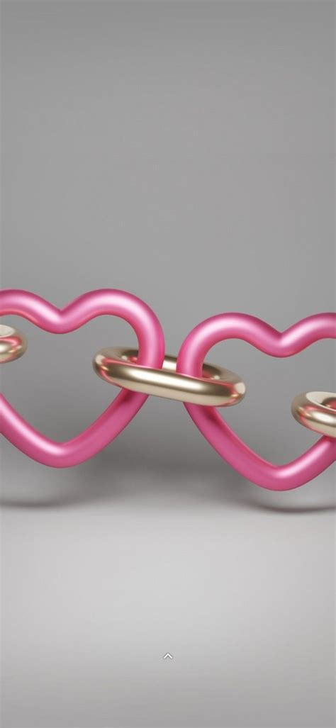 A Pink Heart Shaped Object With Two Gold Chains Attached To It S Sides