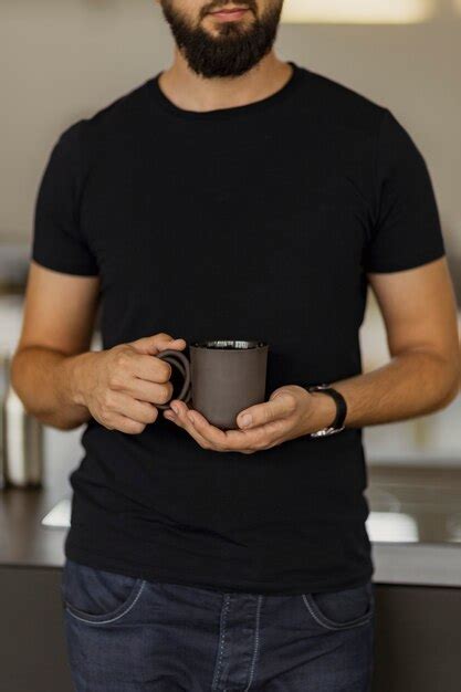 Free Photo A Man Holding A Black Coffee Cup In His Hands