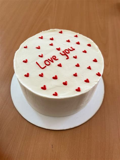 A White Cake With Red Hearts On It