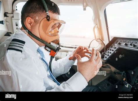 In Oxygen Mask Pilot On The Work In The Passenger Airplane Preparing