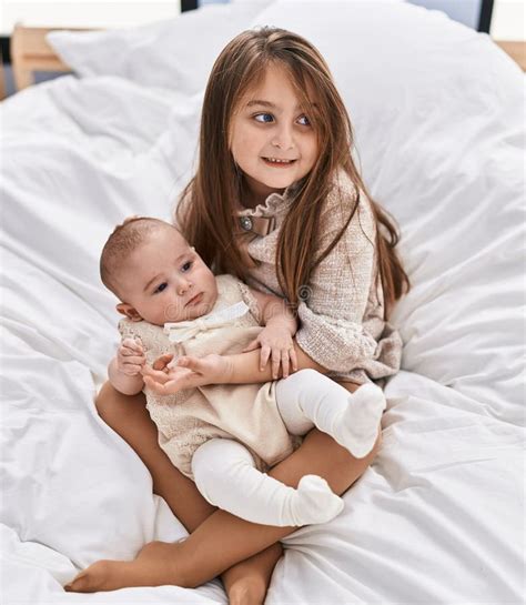 Brother And Sister Hugging Each Other Lying Together On Bed At Bedroom