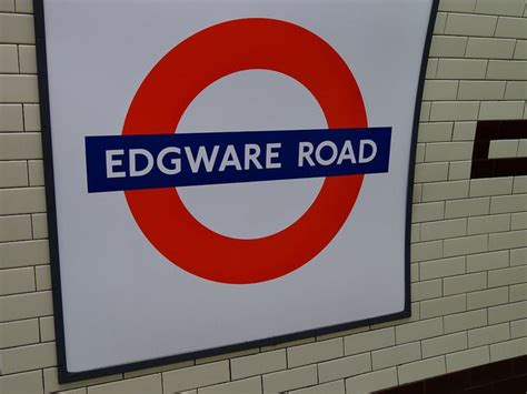 A Sign On The Side Of A Building That Says Edgware Road In Blue And Red