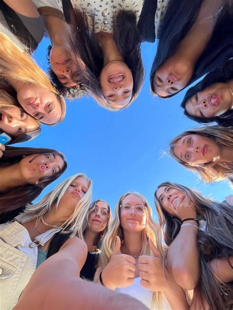 A Group Of Women Standing In A Circle With Their Thumbs Up
