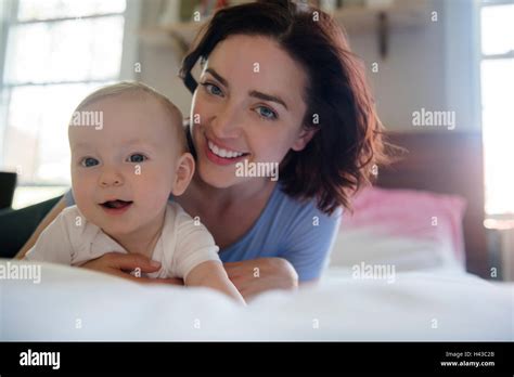 Caucasian Mother Smiling With Baby Son On Bed Stock Photo Alamy