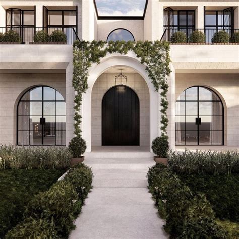 A Large White House With Lots Of Windows And Plants Growing On The Side