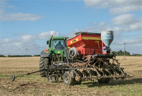 A Green Tractor With A Seed Drill In A Stubble Field Editorial Image