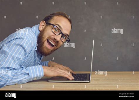 Side View Portrait Of A Joyful Crazy Hacker Or Programmer Sitting At A