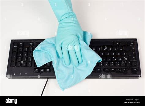 Cleaning Computer Keyboard In Office With A Wet Wipe Rag Dusty And