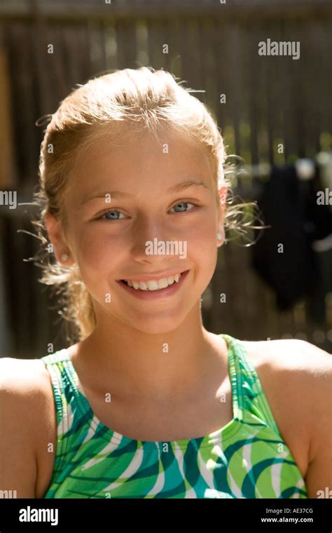 A Pretty Smiling Caucasian Female 12 Is Sitting Outside In The Sun
