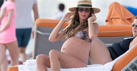 Gisele Bündchen deixa barriga à mostra na praia