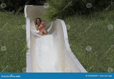 Girl In Bikini Having Fun When Falling Down Water Slide In Water Park