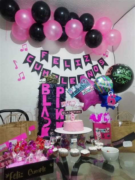 A Table Topped With Lots Of Pink And Black Balloons