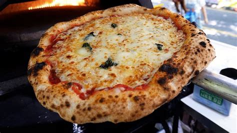 A Pizza Sitting On Top Of An Outdoor Grill