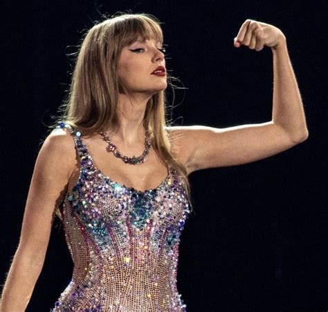 A Woman In A Sequin Dress Flexes Her Muscles At The Camera While