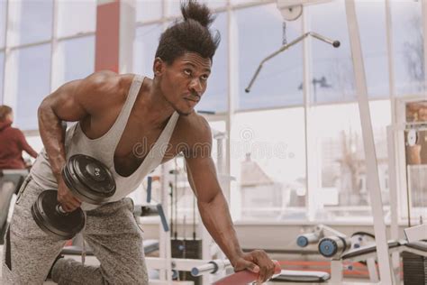 Athletic African Man Working Out With Dumbbells At The Gym Stock Image