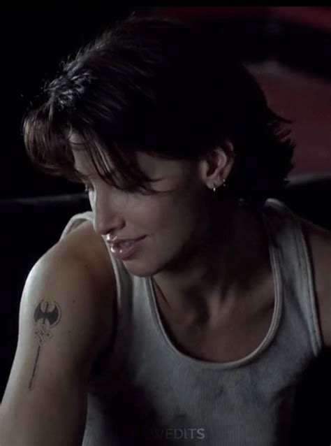 A Woman With Tattoos On Her Arm Sitting Down