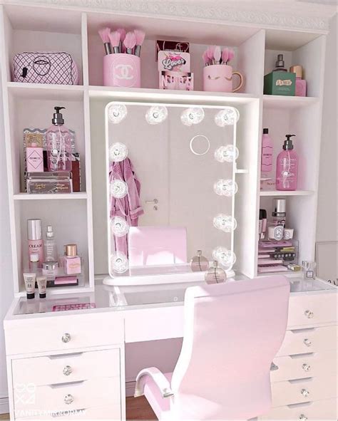 A White Desk Topped With A Mirror And Lots Of Pink Items On Top Of It
