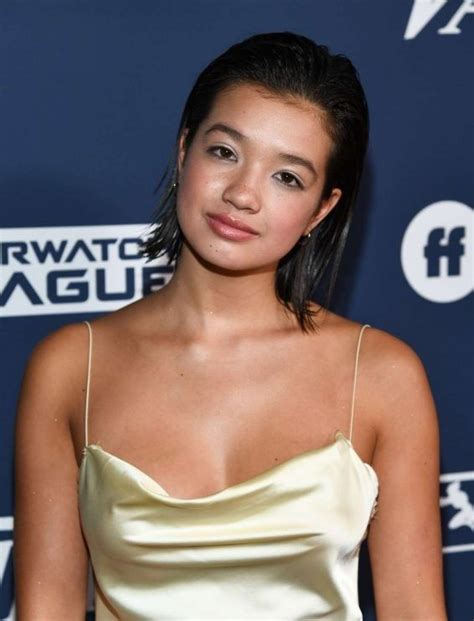 A Woman In A White Dress Posing For The Camera