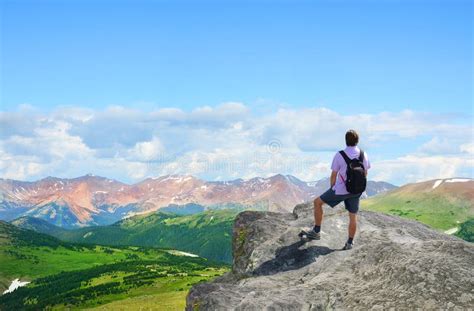 Man Standing On A Top Of The Mountain Enjoying Mountain View Stock