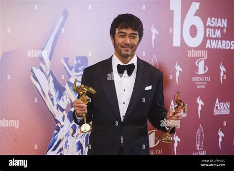 Japanese Actor Hiroshi Abe Holds His Trophy After Winning The