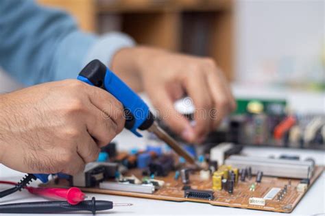 Technician Using A Soldering Iron To Repair A Circuit Board Stock Image