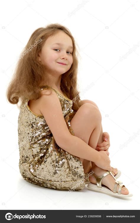 Preteen Girl Sitting On Beach With Barefeet Hugging Knees Stock