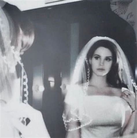A Woman In A Wedding Dress Standing Next To A Man