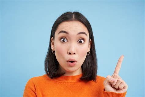 Premium Photo Close Up Portrait Of Asian Girl Looks Surprised Points At Smth Interesting