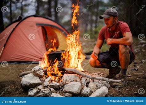 Man Sitting Near The Pot On The Campfire Stock Image Image Of Hand